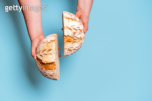 Bread sliced in two held in womans hands. Sourdough bread 이미지 ...