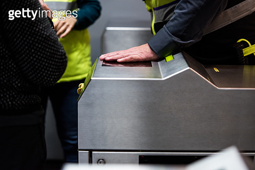 Security guard in subway station. Guard checking an automatic ticket ...