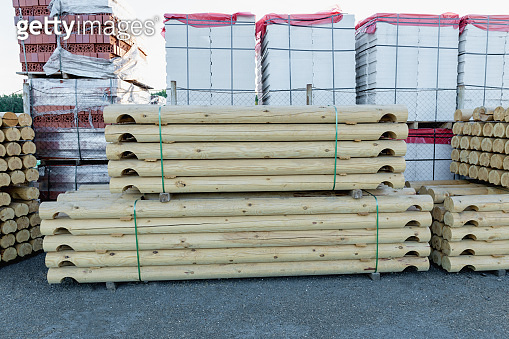 Wooden balk, timber, beam and building material stacked at construction ...