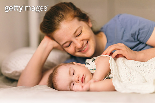 A nine-month-old baby sleeping in bed with his mother. The benefits of ...