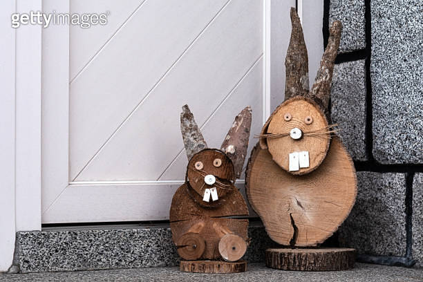 At the front door of the house there are two wooden rabbits. 이미지 ...