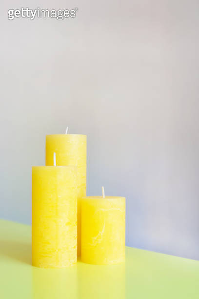 three large yellow candles on a gray background 이미지 (1221478621) - 게티이미지뱅크