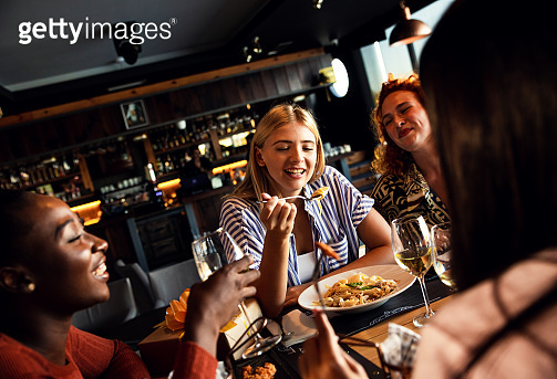 Group of young female friends having fun in restaurant, talking and ...
