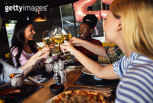 Group of young female friends having fun in restaurant, talking and ...