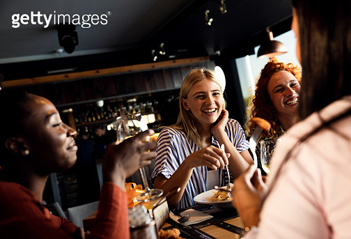 Group of young female friends having fun in restaurant, talking and ...