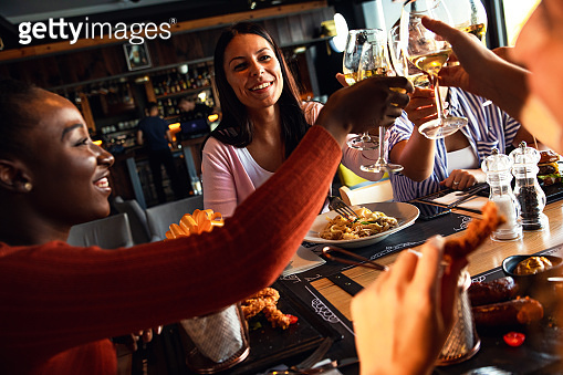 Group of young female friends having fun in restaurant, talking and ...
