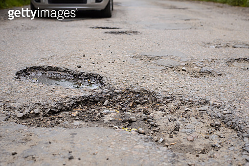 Many enormous potholes in asphalt surface. Concept of bad road ...
