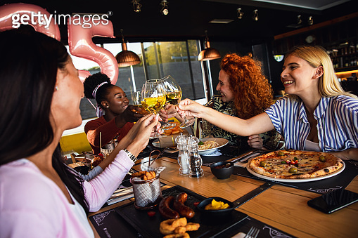 Group of young female friends having fun in restaurant, talking and ...