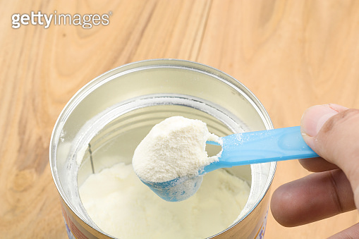 Powder milk and blue spoon on light background close-up. Milk powder ...