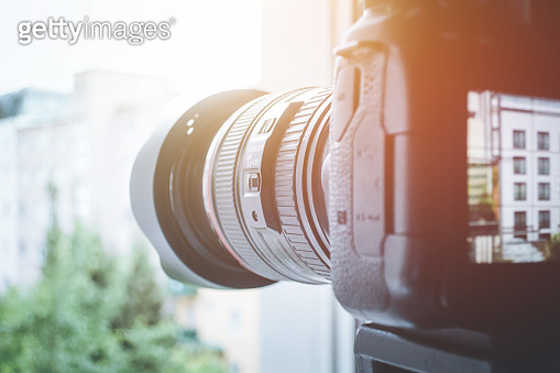 Surveillance and stalking concept: Camera with telephoto lens on tripod ...