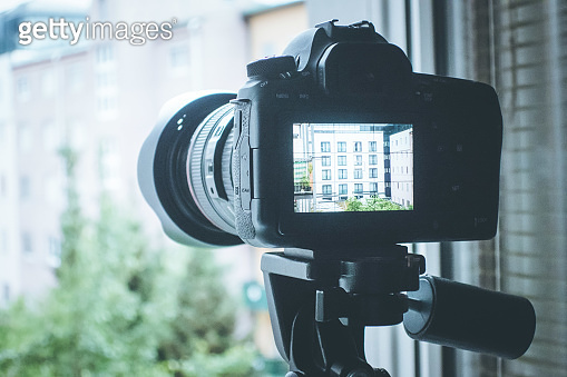 Surveillance and stalking concept: Camera with telephoto lens on tripod ...