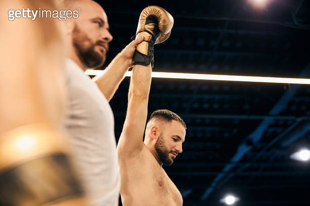 Judge lifting up a hand of a winning athlete (1276661477) - 게티이미지뱅크