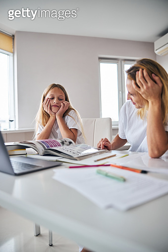 Uninterested pupil giving a look at a boring grammar textbook ...