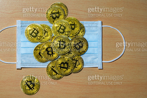 Gold Bitcoin coins with a medical mask (1213055067) - 게티이미지뱅크