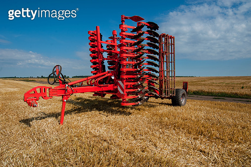 Red harrow folded for transportation for cultivating the land. Harrow ...
