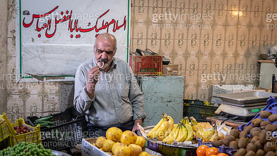 Iranian greengrocer selling fruit in his shop in Grand Bazaar of ...