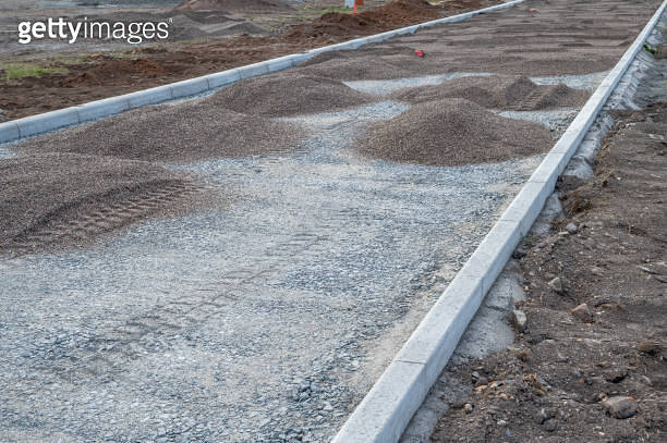 Construction of a road with curb, gravel bed and grit as a sub ...
