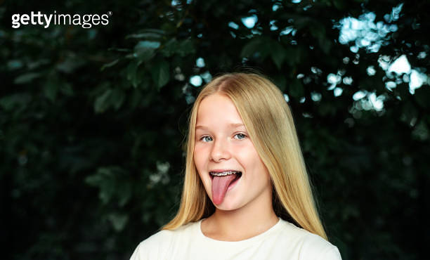 Teenage girl with orthodontic braces sticking out her tongue 이미지 ...