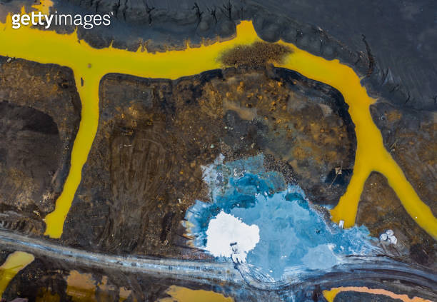 Aerial view drone flying forward over a polluted river with destroyed ...