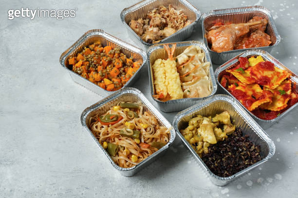 Food delivery lunch box with ravioli, curry chicken rice, gyoza tempura ...