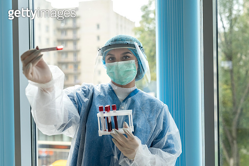 nurse wearing face shield uniform holding positive blood test result ...
