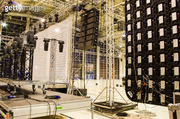 Moving head spotlight devices on a truss. Line array speakers. Big led ...