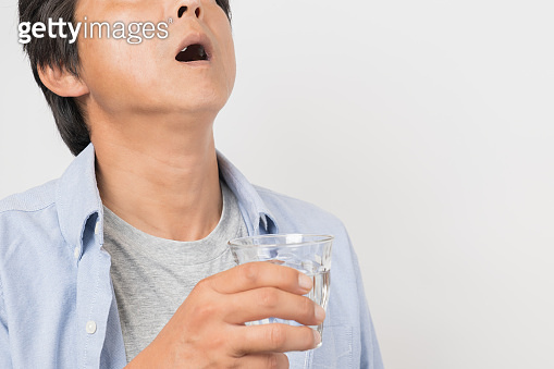 A man gargling with water poured into a glass 이미지 (1293837784) - 게티이미지뱅크