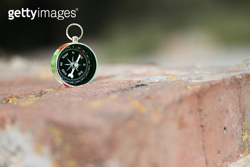 Iron compass on brick wall as symbol of tourism with compass ...