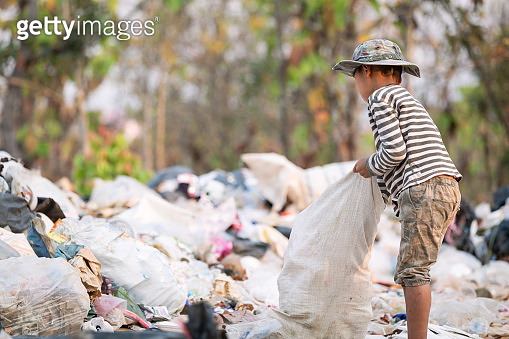 Poor boy collecting garbage in his sack to earn his livelihood, The ...