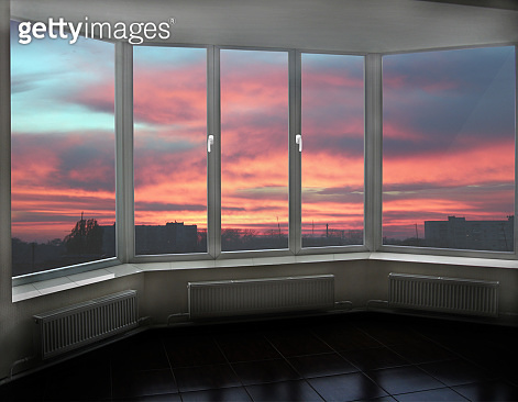 Panoramic window with view of red sunset above city buildings 이미지 ...