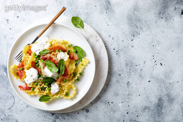 Italian pasta mafalde with green peas, prosciutto, burrata, and spinach ...