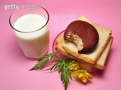 Dry rusk bread choco pie chocolate and a glass of milk isolated on pink ...