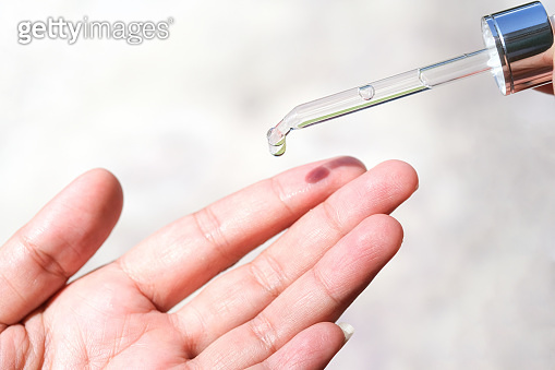 hands of a beautiful woman Dropping serum collagen moisturizer of face ...