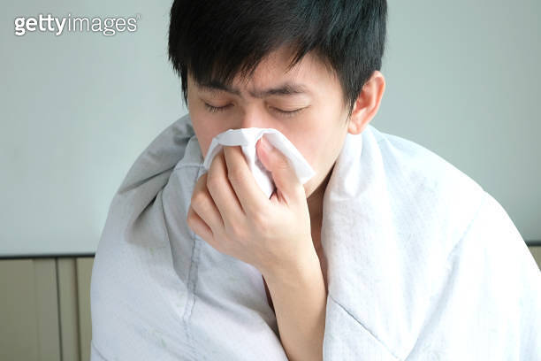 Sick man is flu, using a paper napkin and he have a runny nose. And he ...