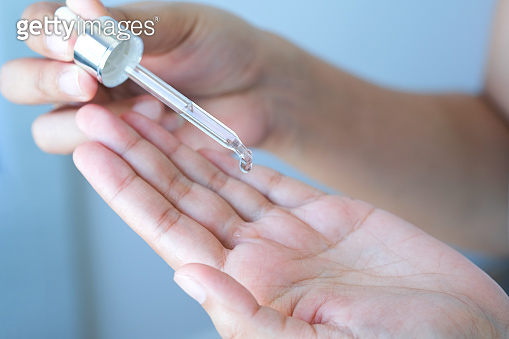 hands of a beautiful woman Dropping serum collagen moisturizer of face ...