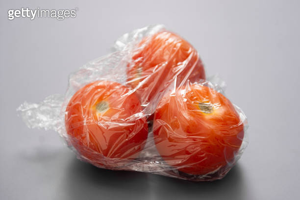 Closeup tomatoes in wrapping plastic stretch film, abstract plastic ...