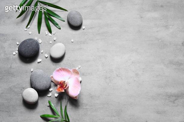 Spa concept on stone background, palm leaves, flower, zen, grey stones ...
