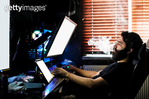 bearded gamer man vaping smoking playing, designing, working on high ...