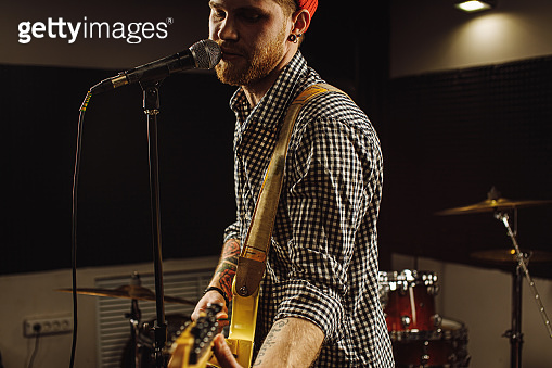 young gorgeous musician play electric guitar and sing in studio 이미지 ...