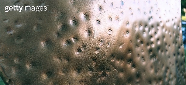 Bronze metal surface. Uneven metal texture with scratches, gouges and ...