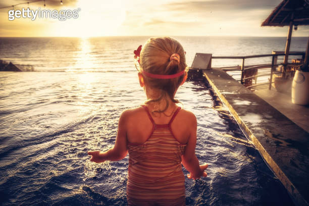 Happy child toddler swimming infinity swimming pool at sunset as travel ...