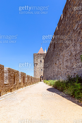 Wide fortified walls with walkways and arches of medieval castle of ...