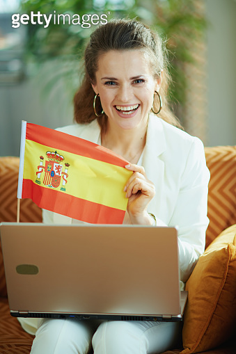 woman with laptop having video call and showing Spanish flag 이미지 ...