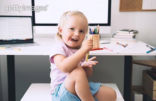Little girl studying and drawing at desk. Preschool child using ...