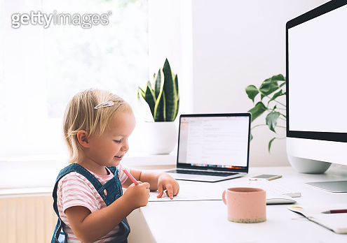 Little girl studying and drawing at desk. Preschool child using ...