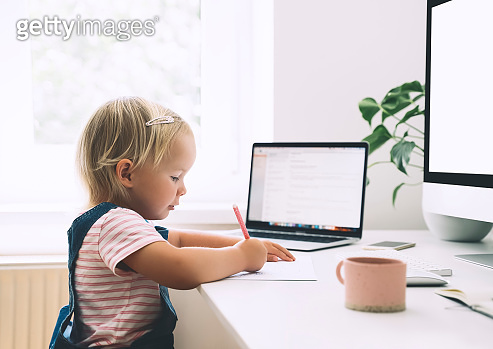 Little girl studying and drawing at desk. Preschool child using ...