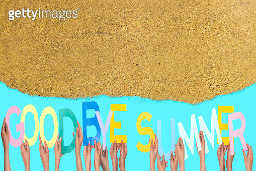people forming goodbye summer holding letters and sand background ...