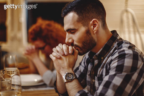 Grateful man praying before a meal at dining table. (1208593361) - 게티이미지뱅크