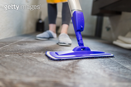 Maid doing chores at home by holding mopping stick. Coronavirus ...
