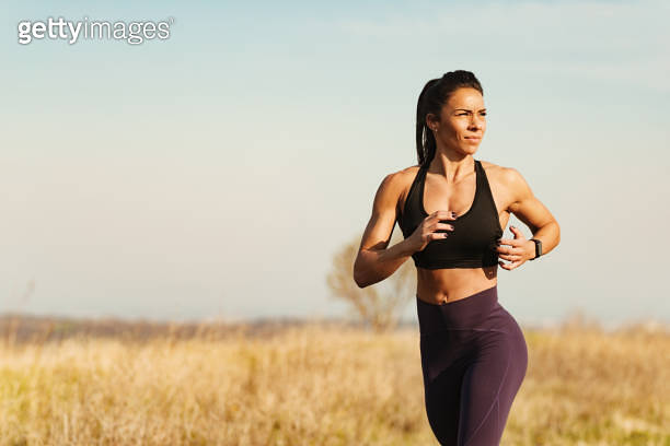 Young muscular build woman running while exercising in nature. 이미지 ...